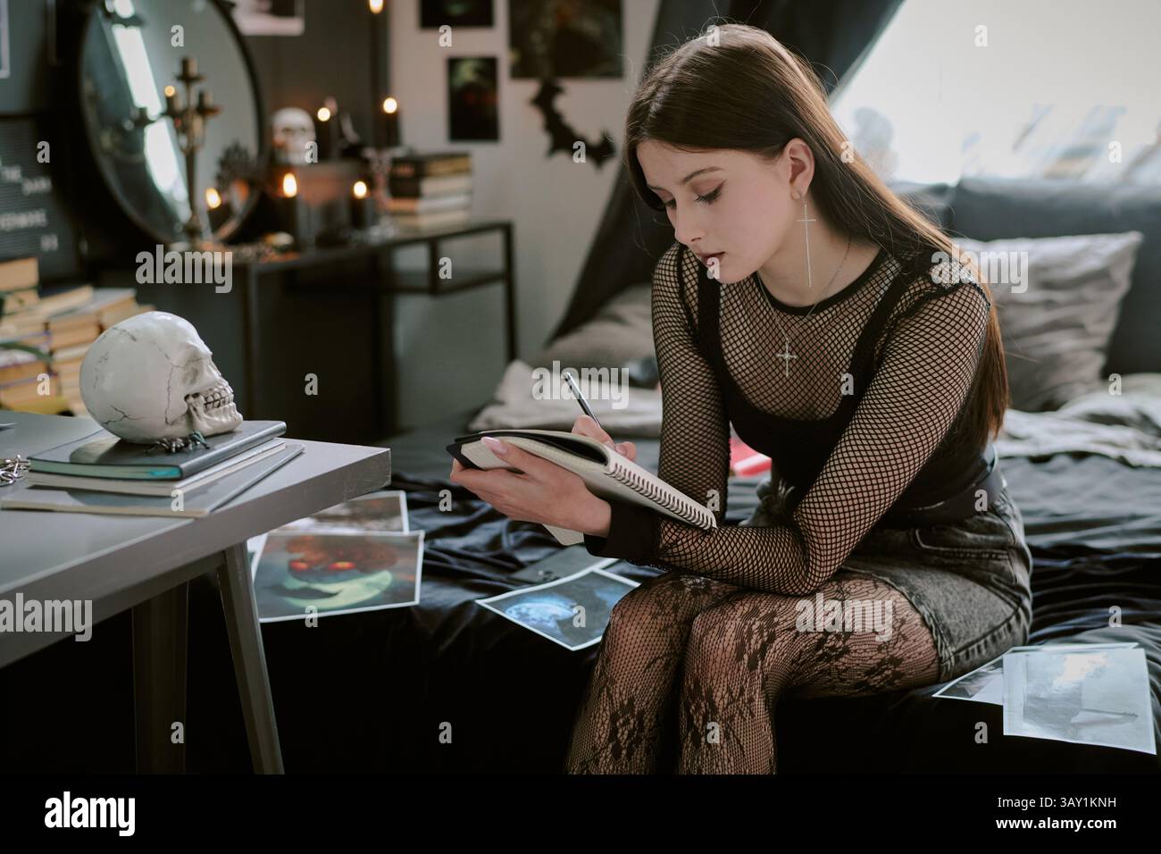 Brunette goth teen in black clothes with dark make up and cherry lips ...