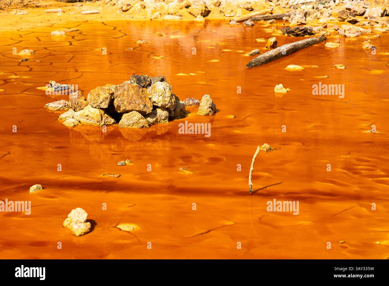 Rock pile and mineral-stained toxic orange water in the abandoned ...