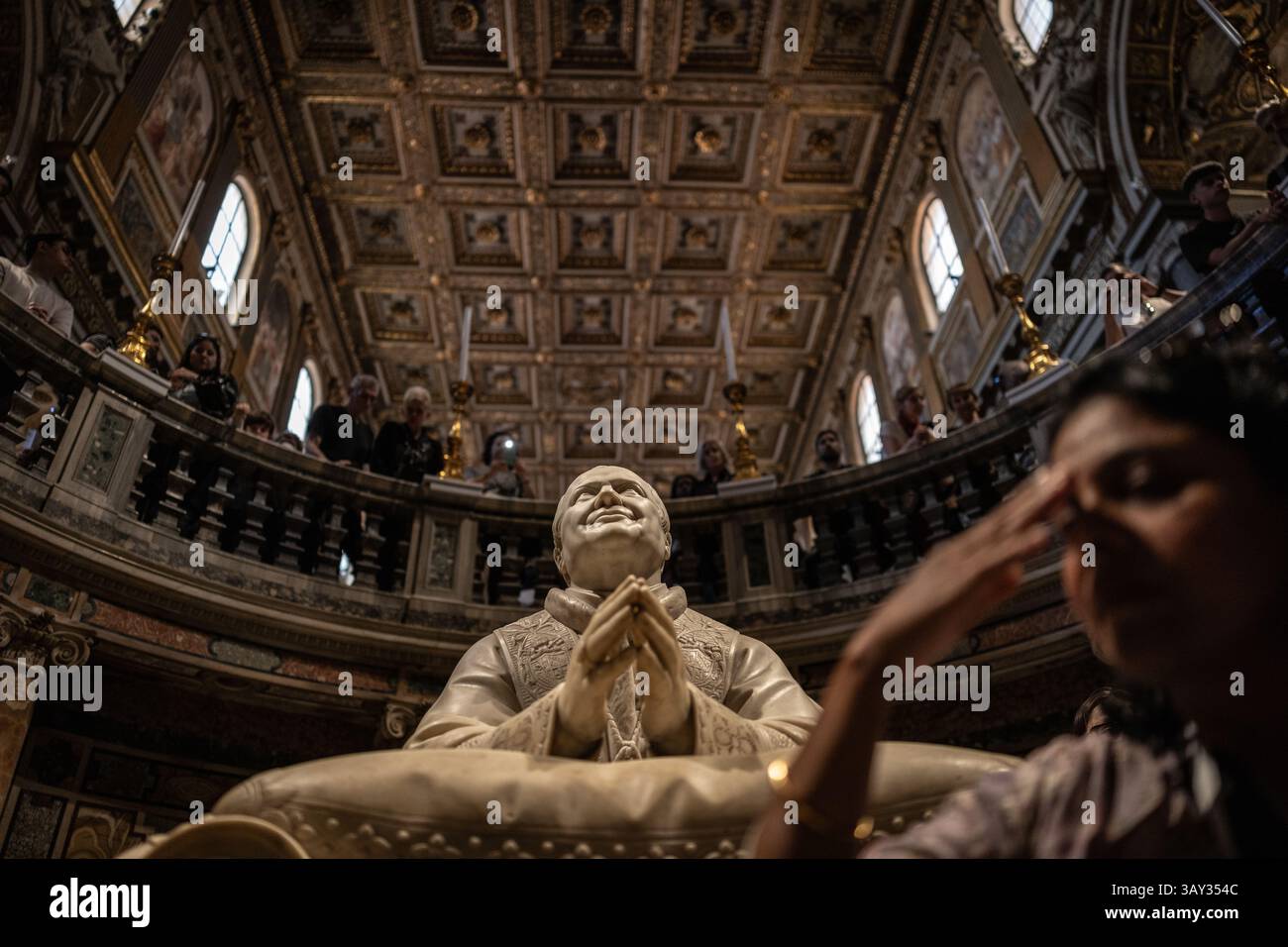 Rome, Italy. 22nd Apr, 2025. Pilgrims walk past the marble statue of Pope Pius IX in the ...