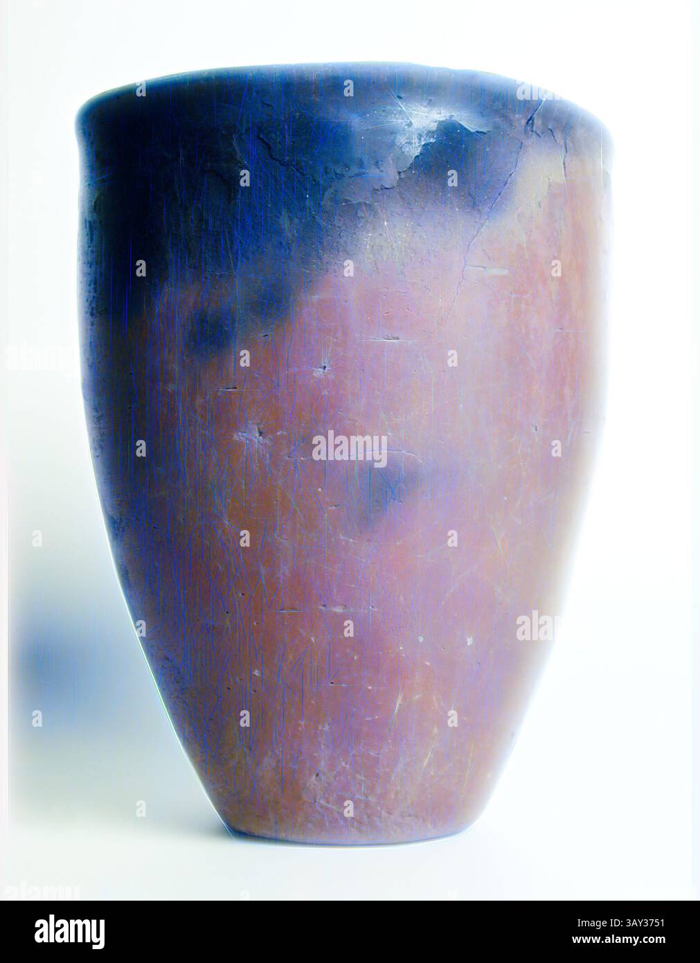 A tall, uniquely shaped vessel displays a rich blend of earthy tones ...