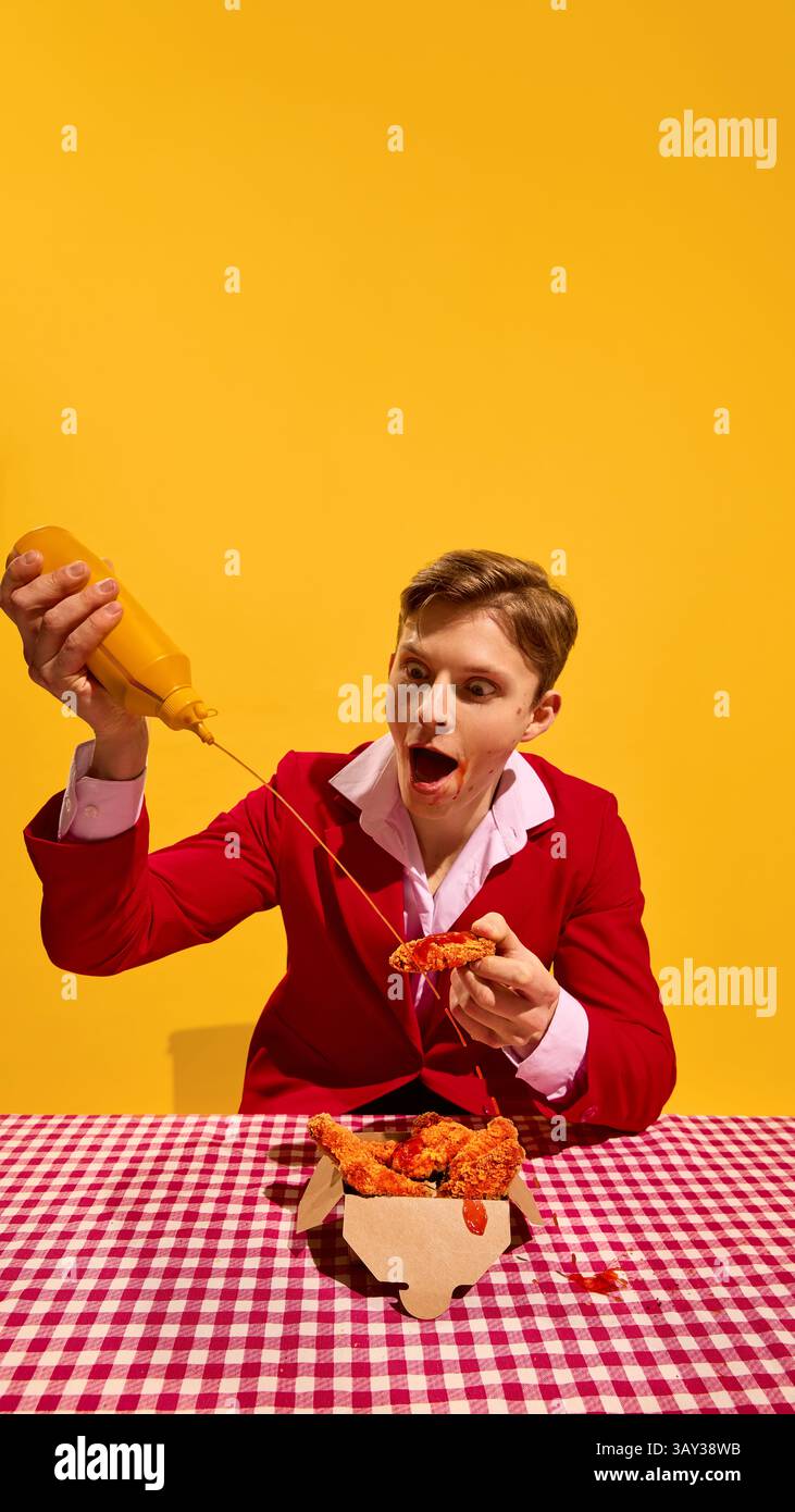Man holding crispy chicken while pouring mustard sauce with exaggerated ...