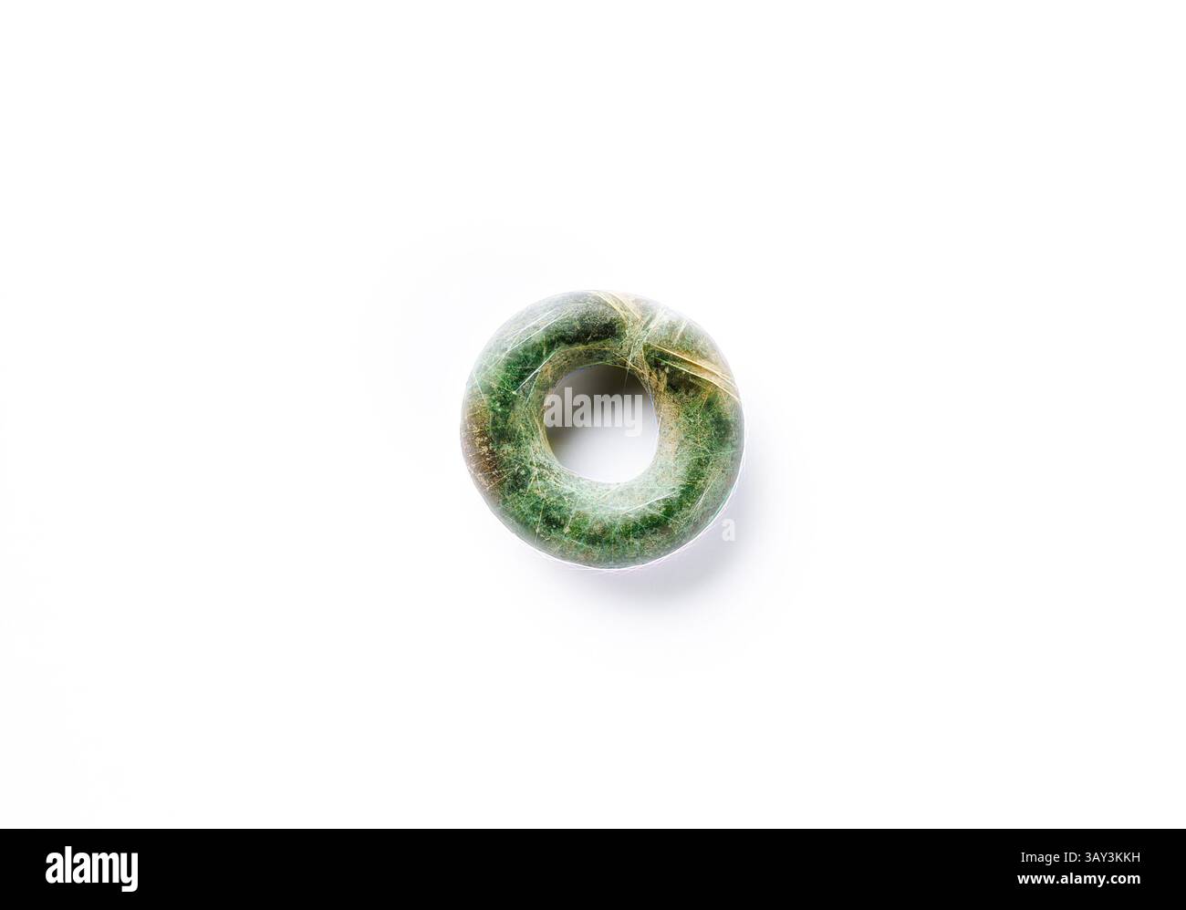 A circular jade artifact with a rich green hue and natural inclusions ...