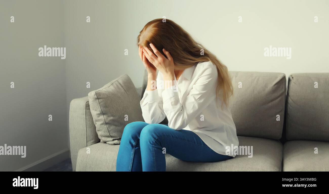 Upset sad crying woman covering her eyes and face with her hands while ...