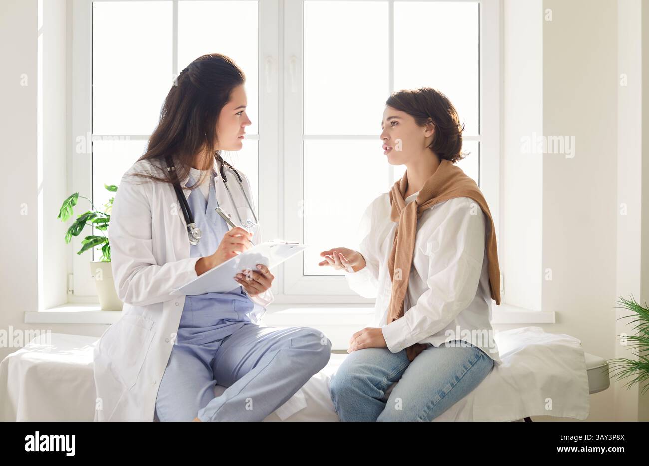 Young female GP doctor talking to patient, explaining prescription ...