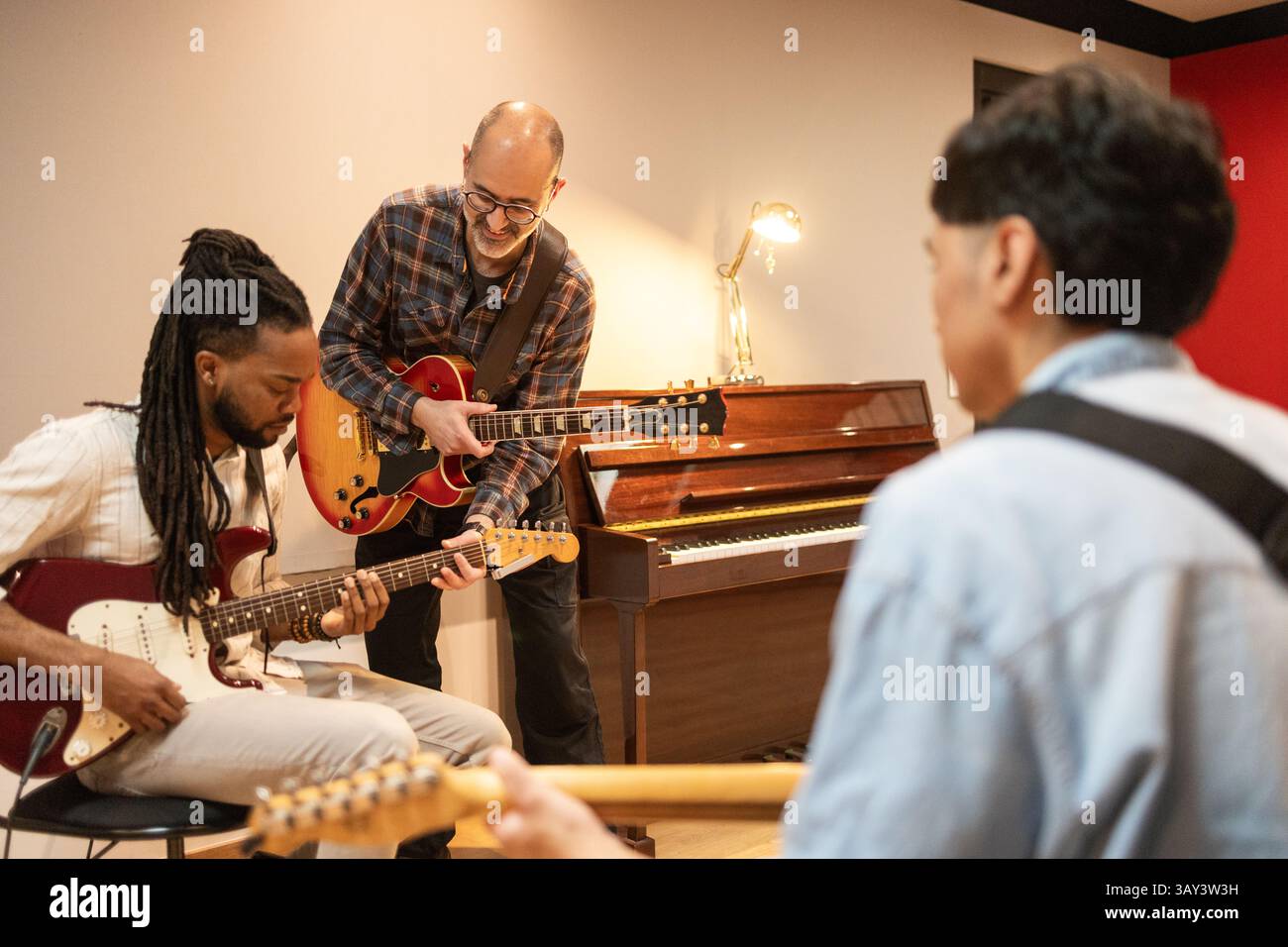 A diverse group of musicians jam in a cozy recording studio. Electric ...