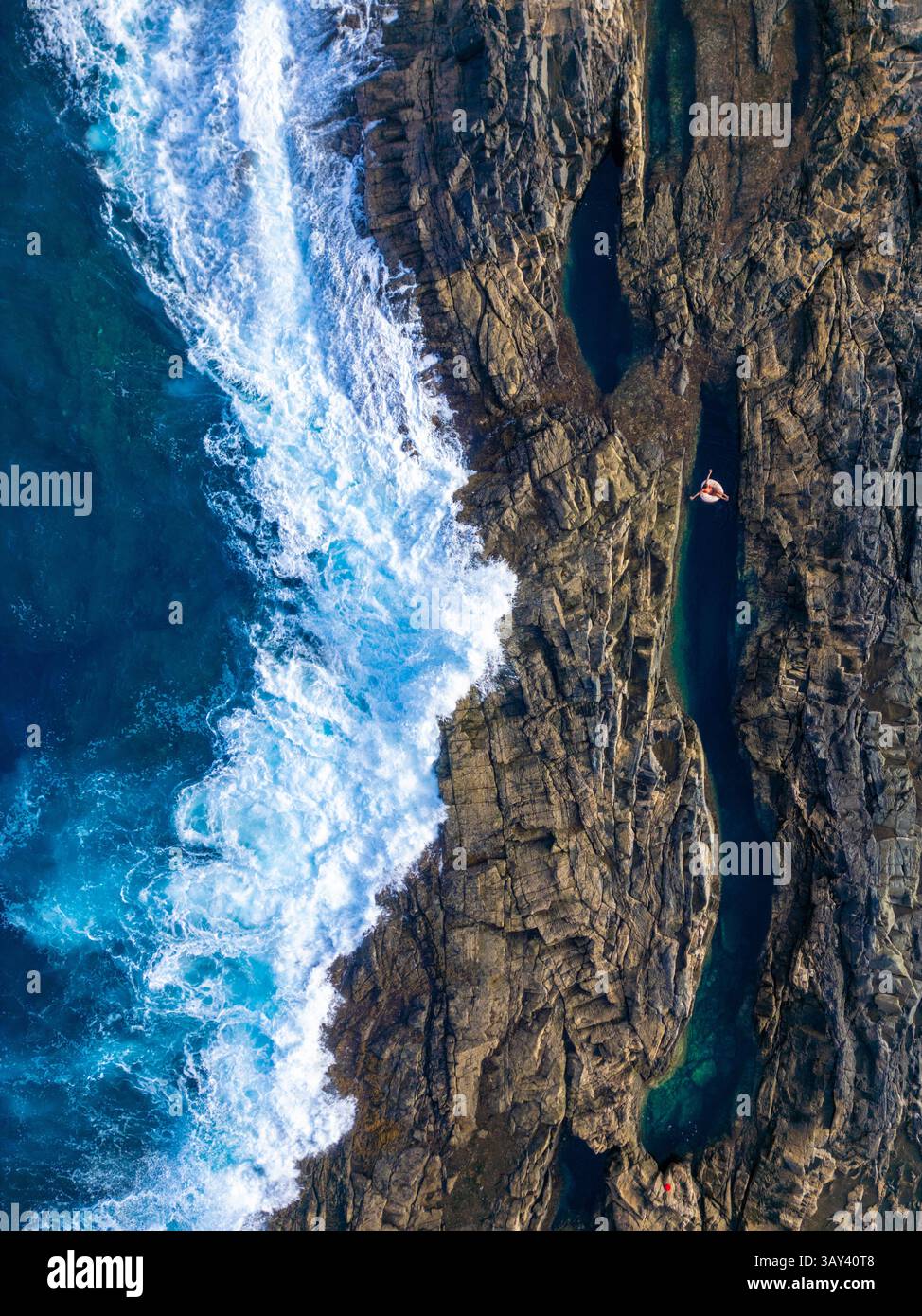 Top aerial drone view of an anonymous woman relaxing on an inflatable ...