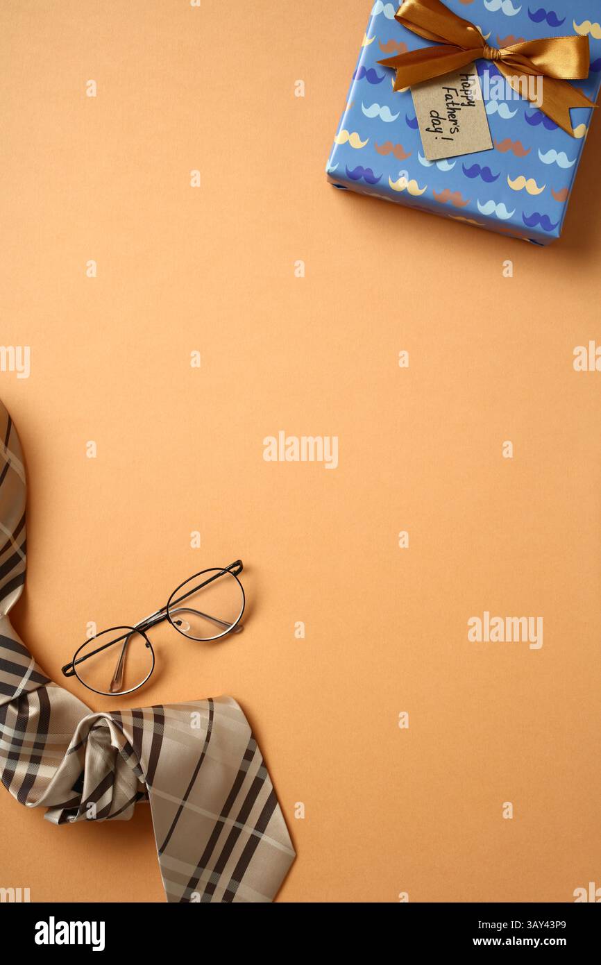 Top view of a thoughtful Father's Day setup featuring a patterned blue gift box with a Happy ...