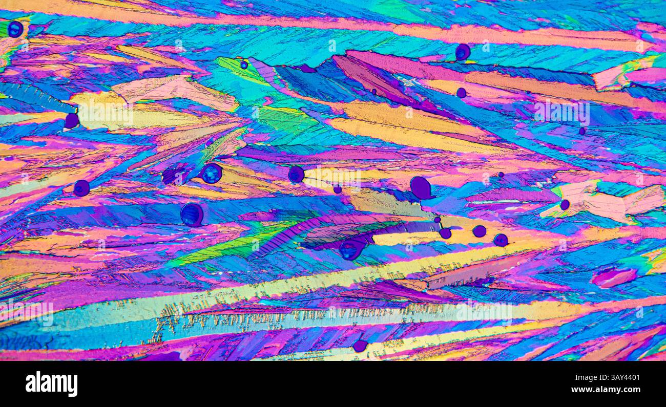 Microscopic image of Adipic acid, crystals in hues of pink, blue ...