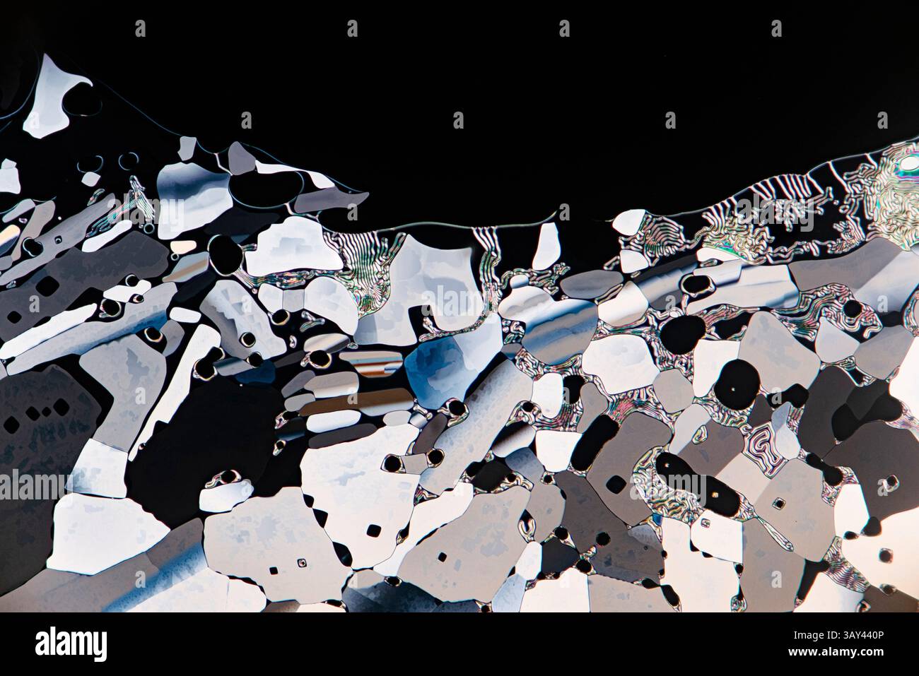 A vivid display of liquid crystals viewed under a microscope, showcasing a complex mix of blues ...