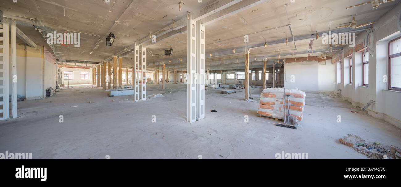 Wide, open industrial space with exposed concrete pillars and beams ...