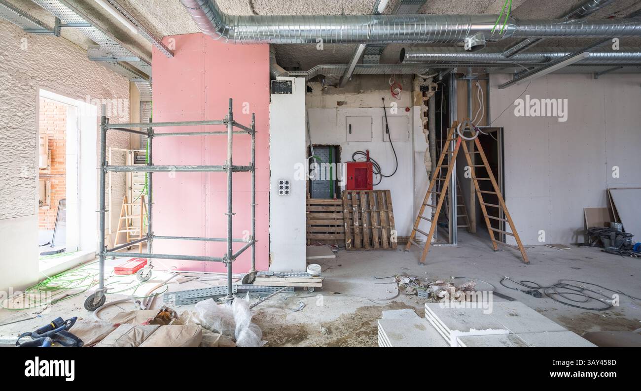 Interior view of a renovation site featuring scaffolding, ladders, and ...