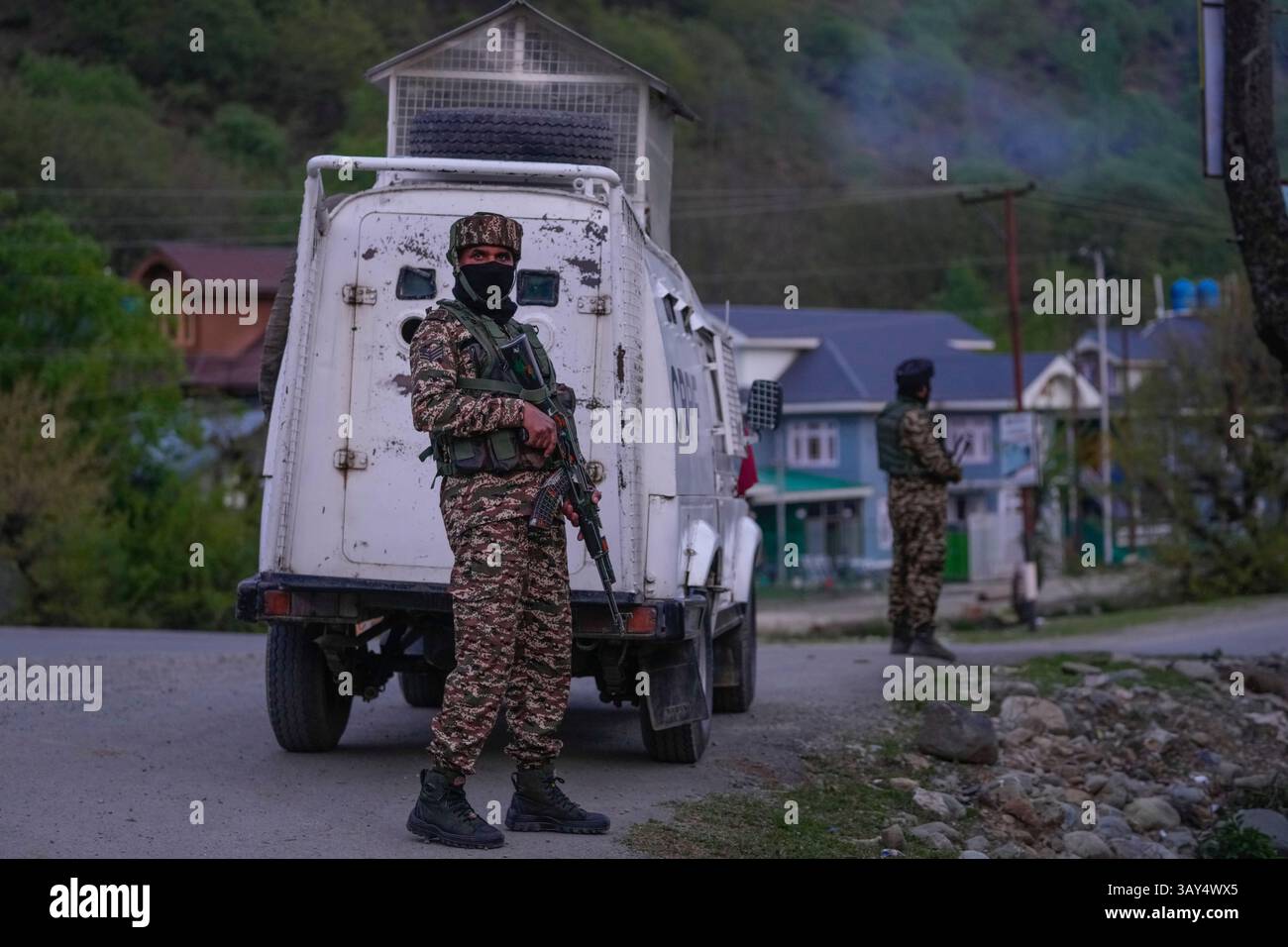 Indian security officers stand guard on a highway in south Kashmir ...