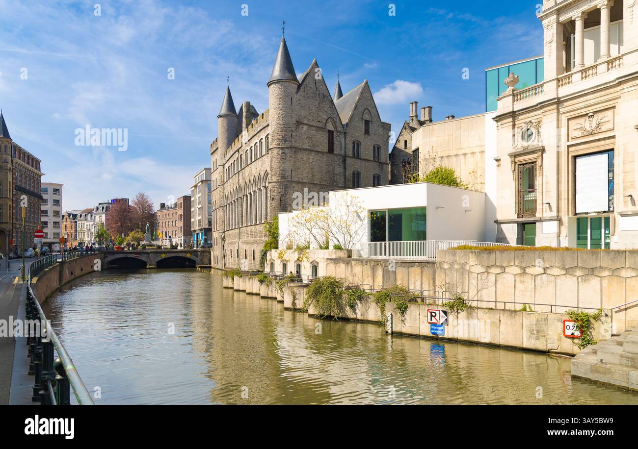 Historic stone building alongside a canal in Ghent, Belgium, reflecting on the water under a ...