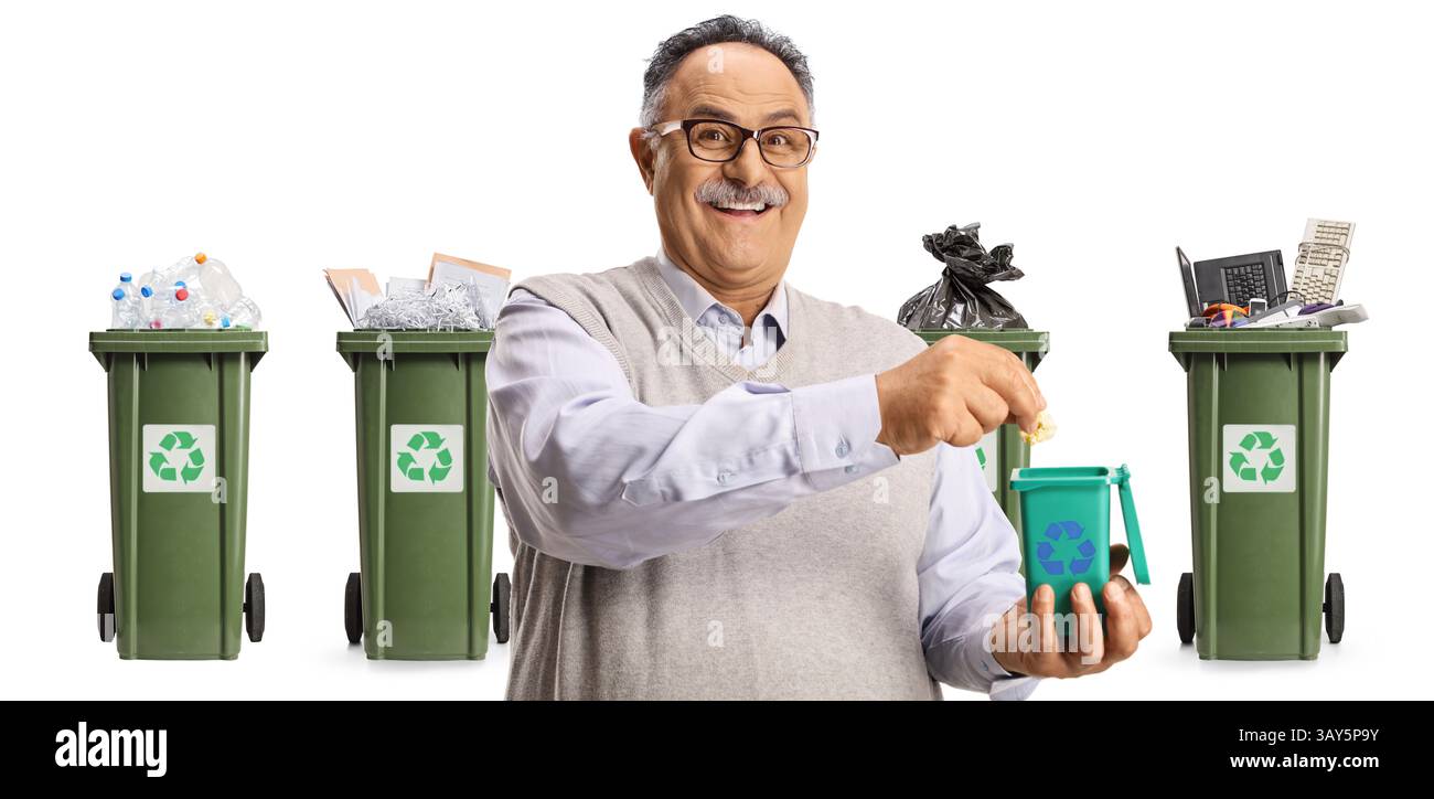 Mature man throwing waste in a small green plastic bin and recycling ...