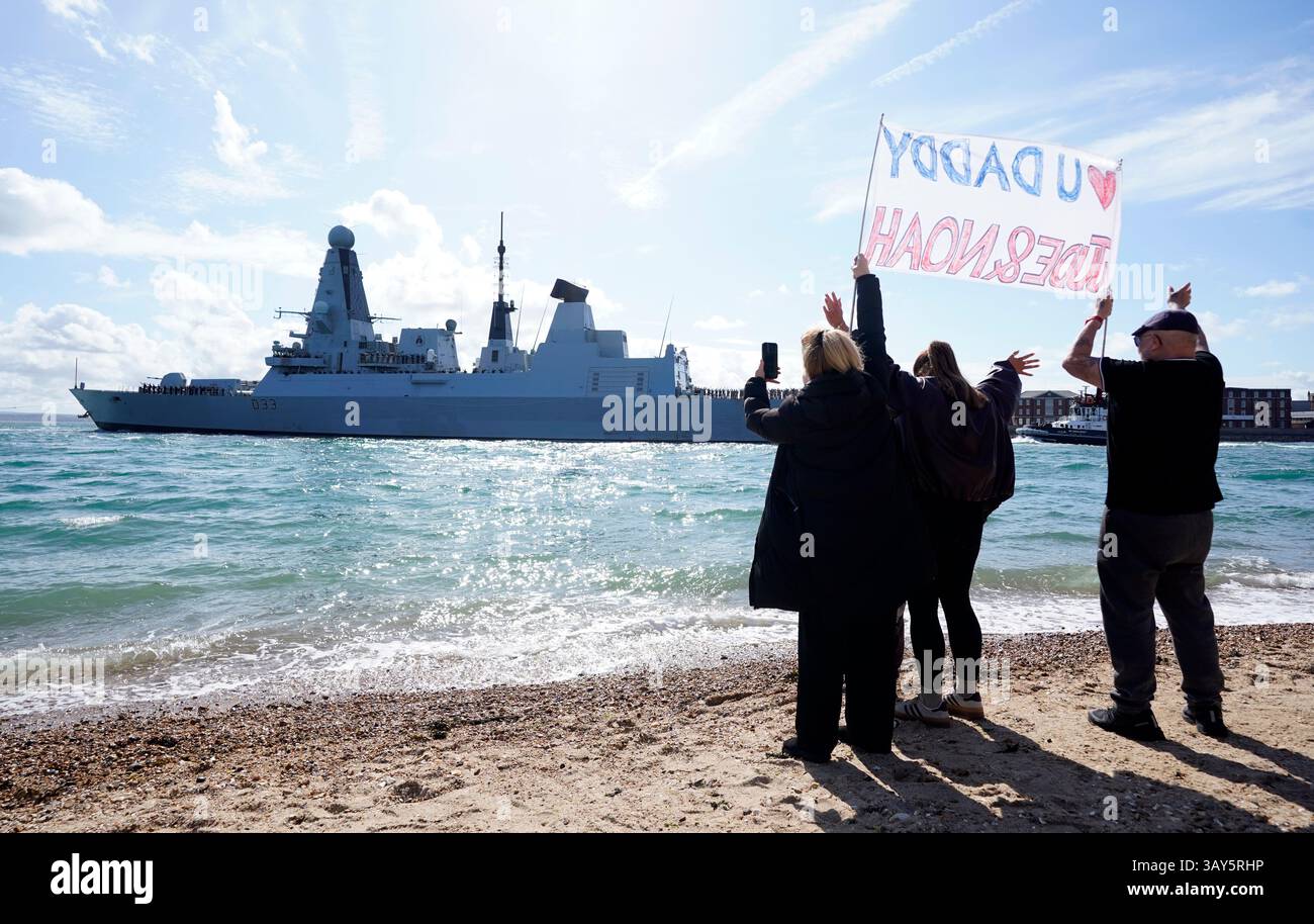 People wave from the beach towards the Royal Navy Type 45 Destroyer HMS ...