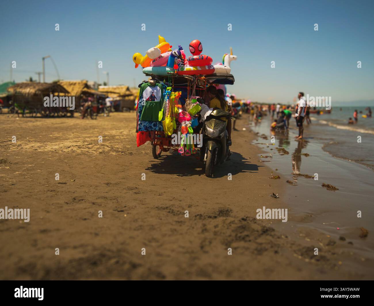 A mobile vendor on a sandy beach in a Philippines offers a variety of ...