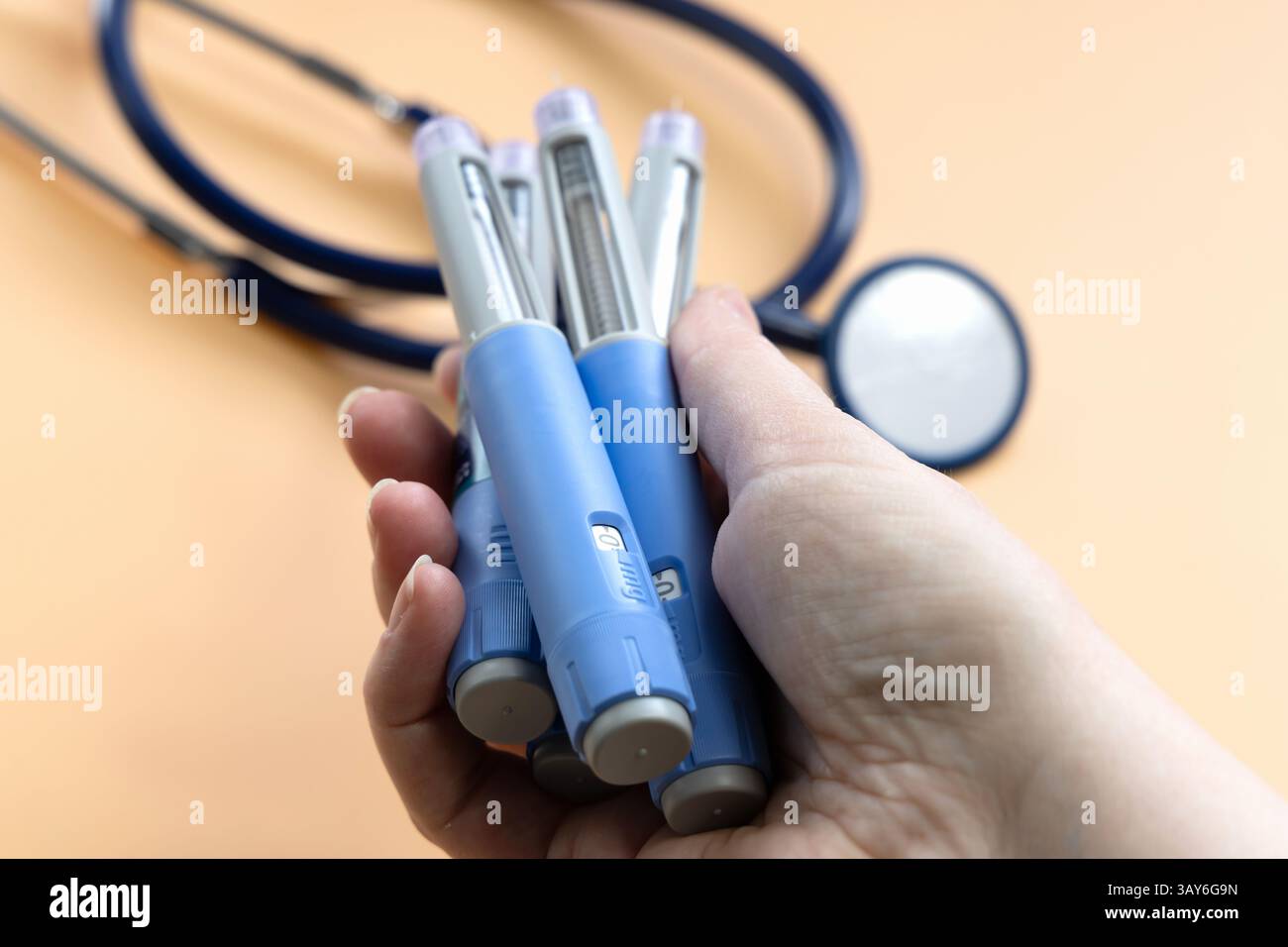 Women's hands holding lots of blue Insulin injection pen for diabetics ...