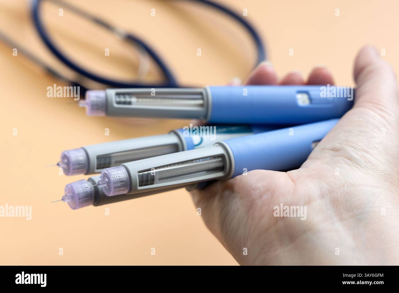 Women's hands holding lots of blue Insulin injection pen for diabetics ...