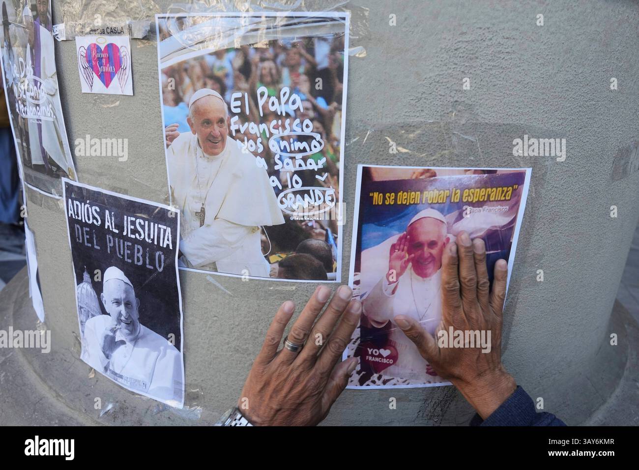 Norberto Rodriguez places a photo of the late Pope Francis on a column ...