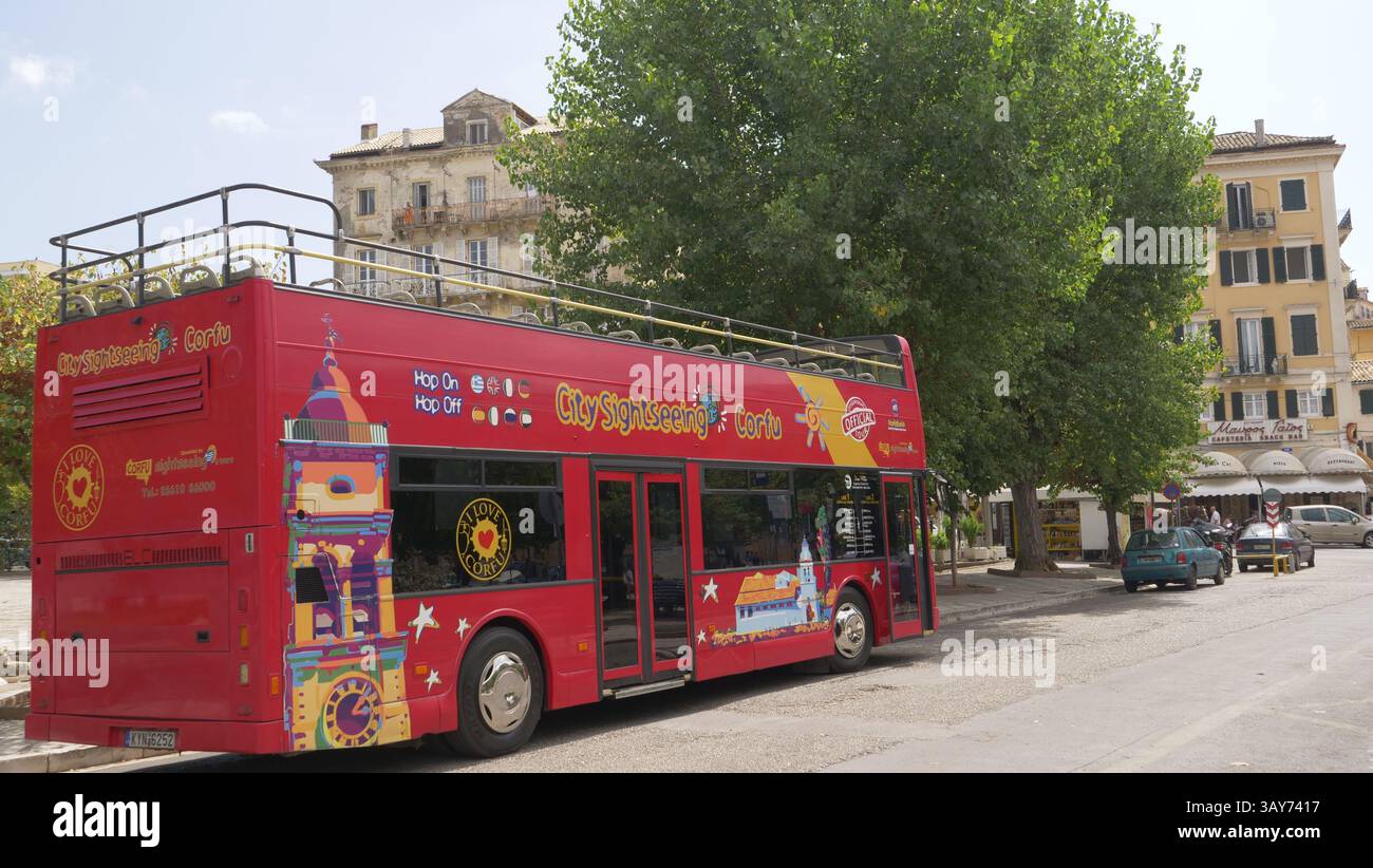 A tourist bus wait to take tourists on a guided tour of Corfu town ...