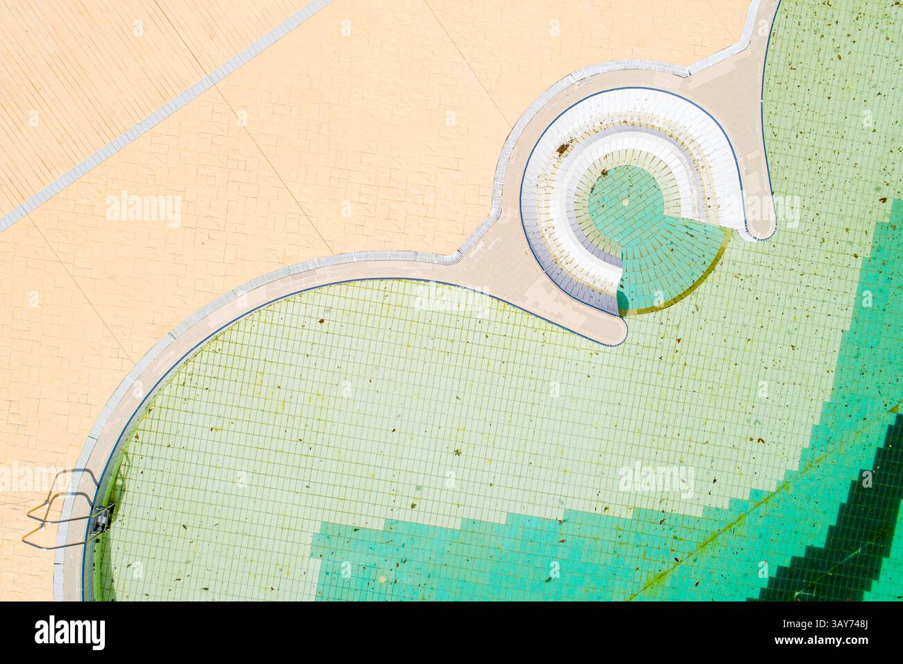 drone shot of an abandoned pool with discolored green water, top down ...