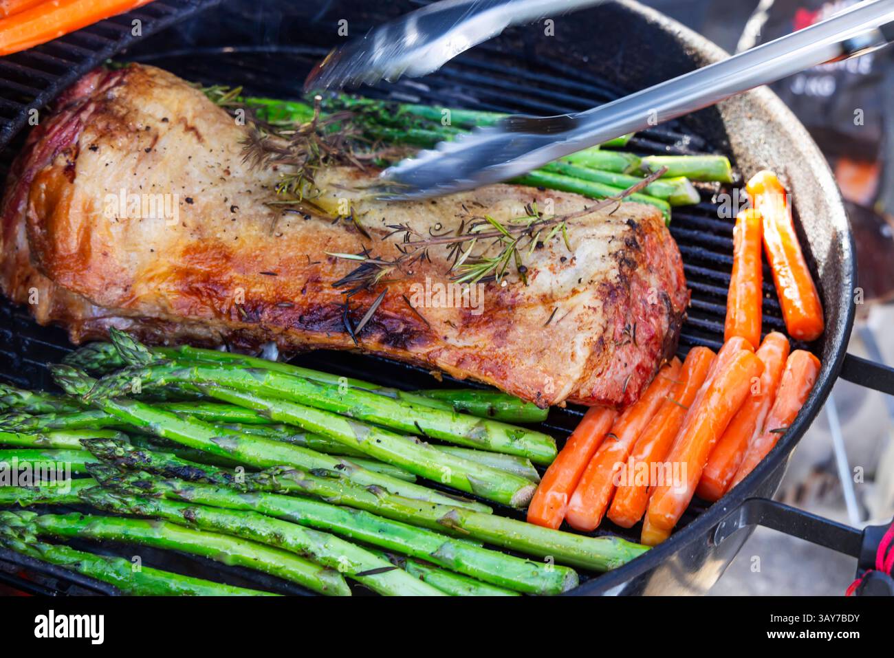 Barbecue zu Ostern. Lammrücken grillt auf einem Kugelgrill im Freien ...