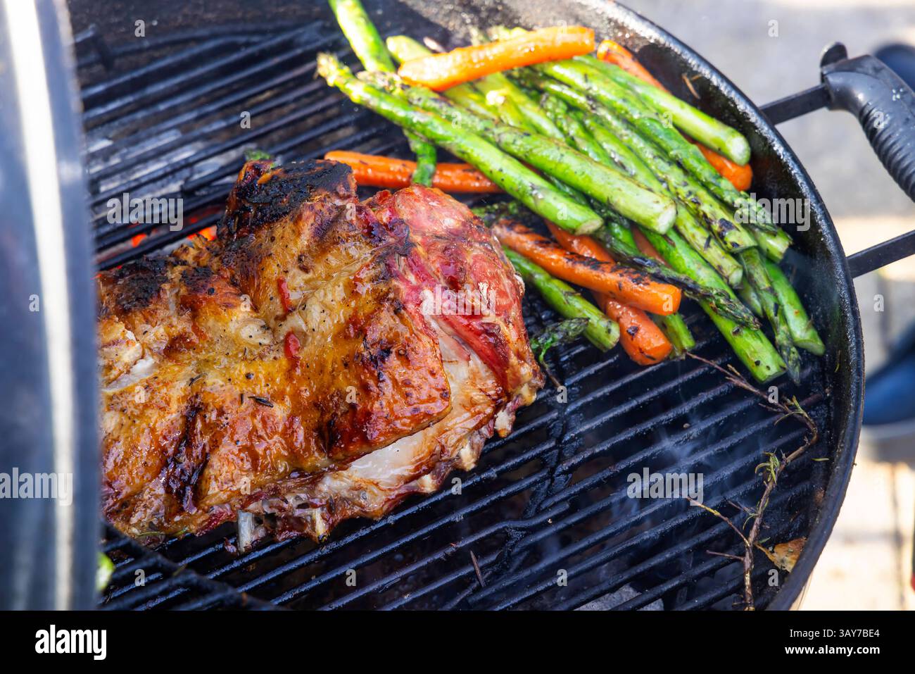 Barbecue zu Ostern. Lammrücken grillt auf einem Kugelgrill im Freien ...