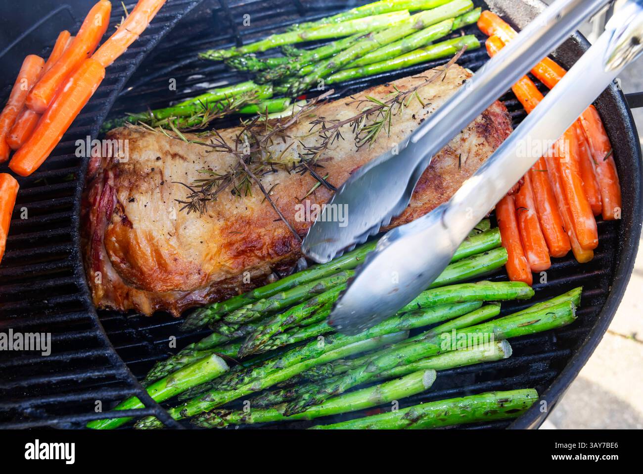 Barbecue zu Ostern. Lammrücken grillt auf einem Kugelgrill im Freien ...