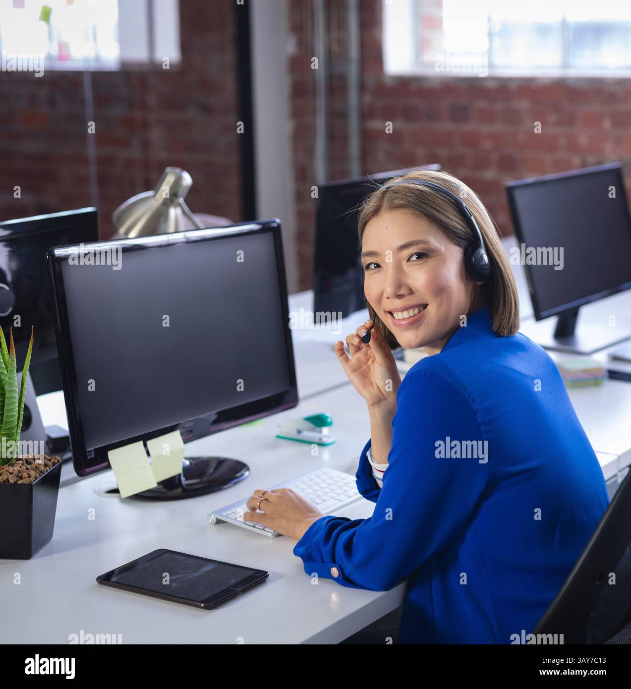 Woman seated desk typing monitors hi-res stock photography and images ...