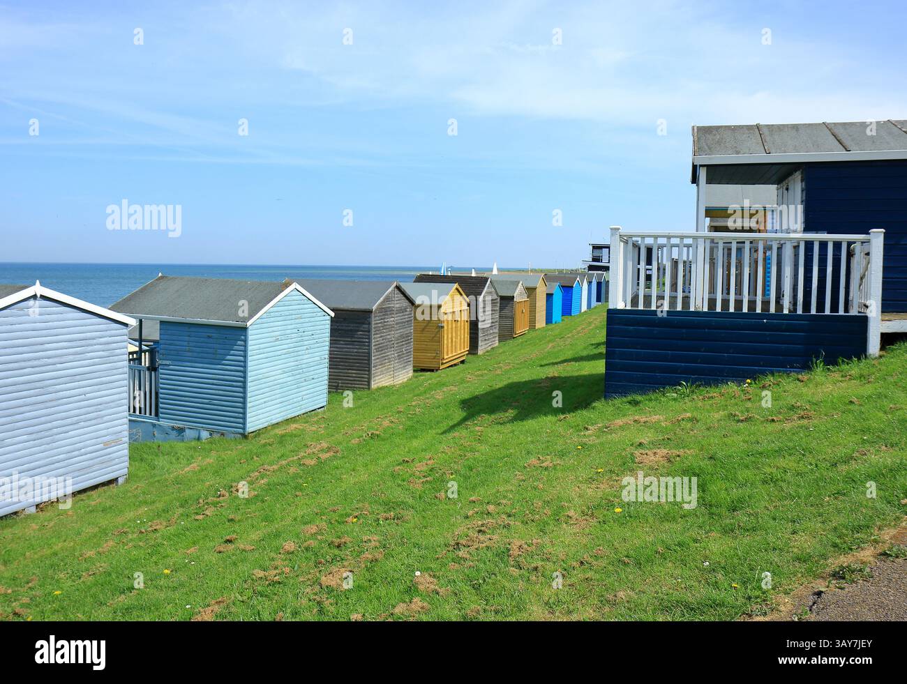 Rows of colourful beach huts looking out over the sea front at ...