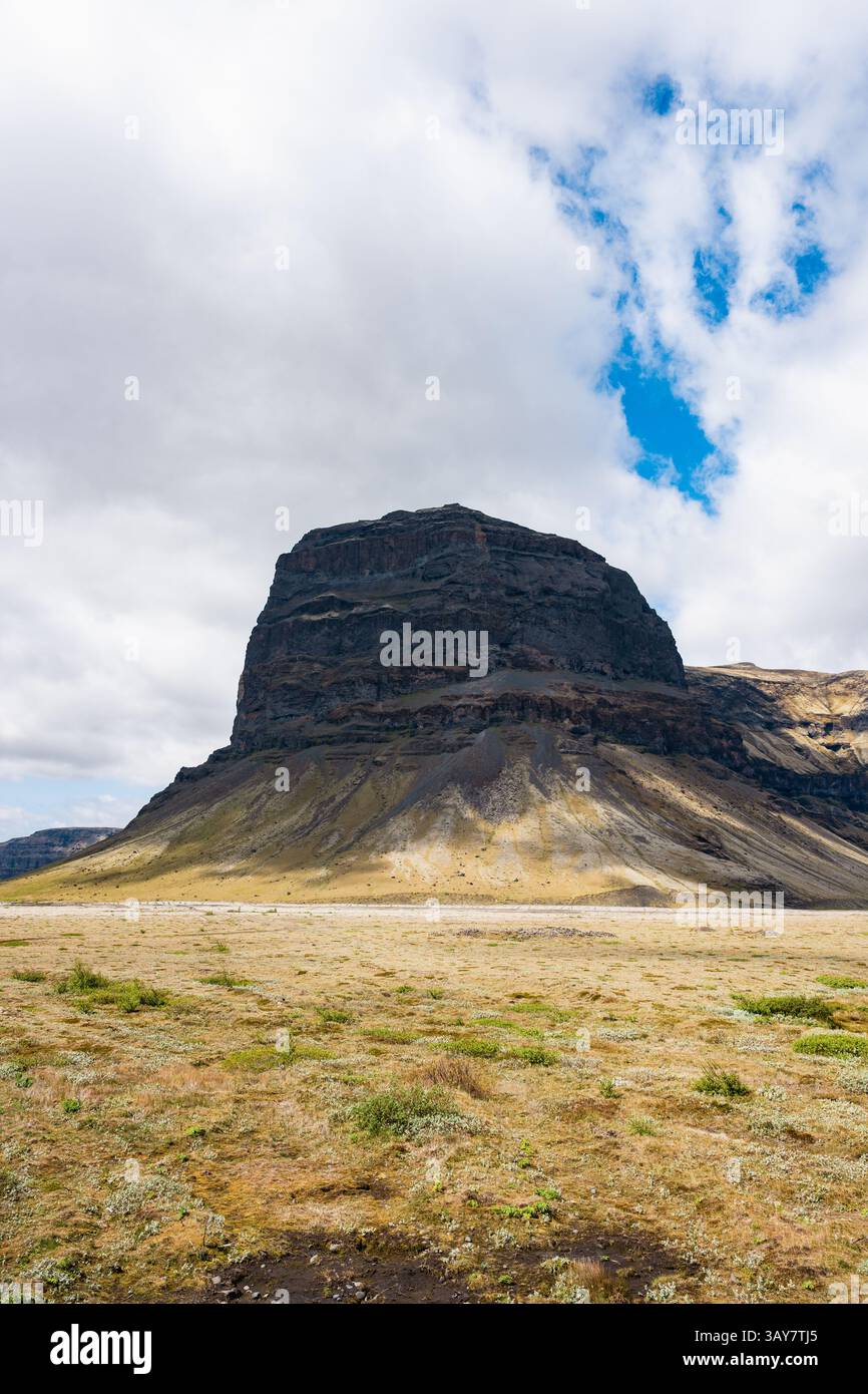 Tall, stratified volcanic rock formation in Icelandic wilderness, with ...