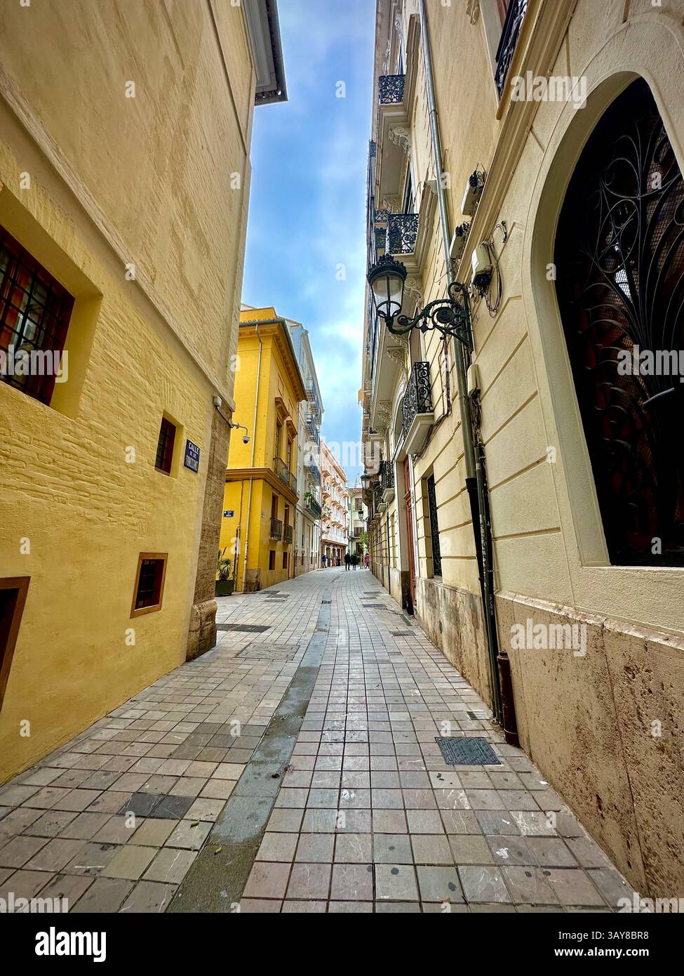 A narrow alley in Valencia's historic center, surrounded by colorful ...