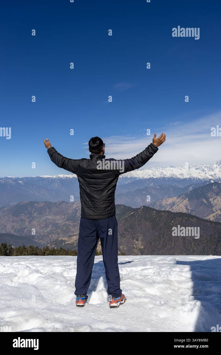 man embracing victory and thank you gesture at trekking summit with ...