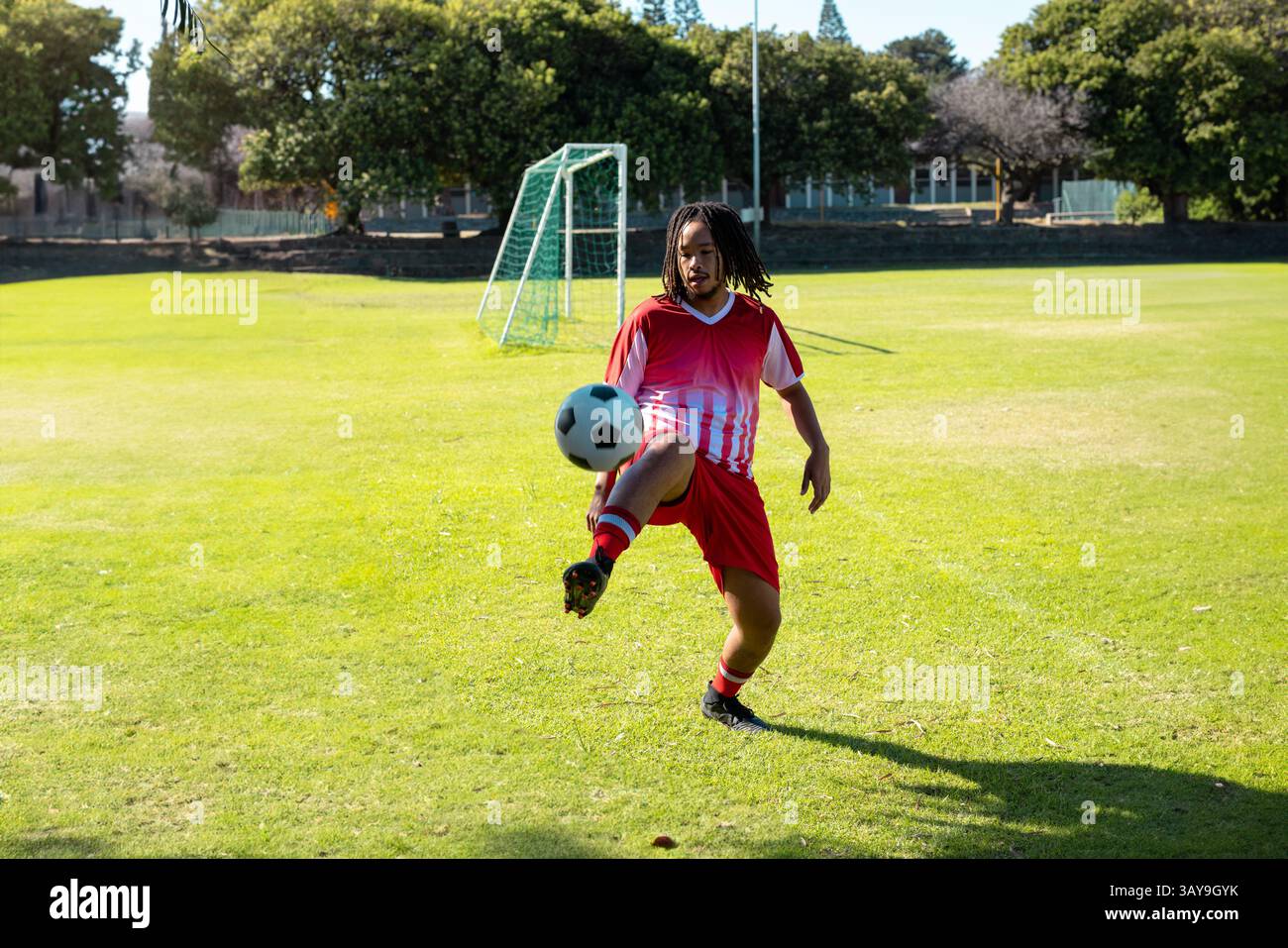male soccer player juggling black-and-white ball on soccer field at ...