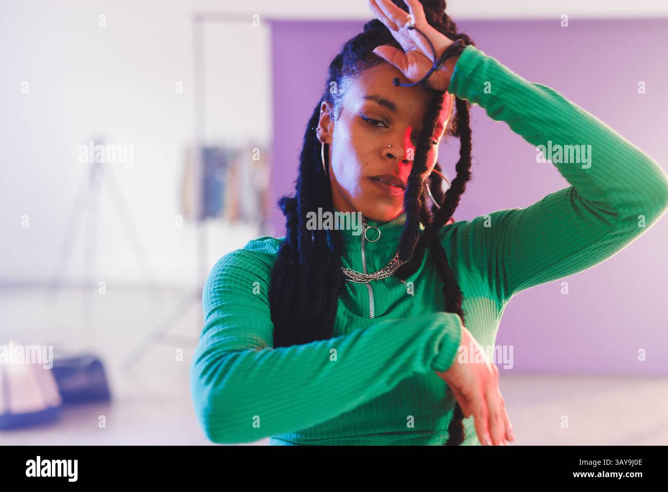 African American woman striking expressive dance pose in studio with ...