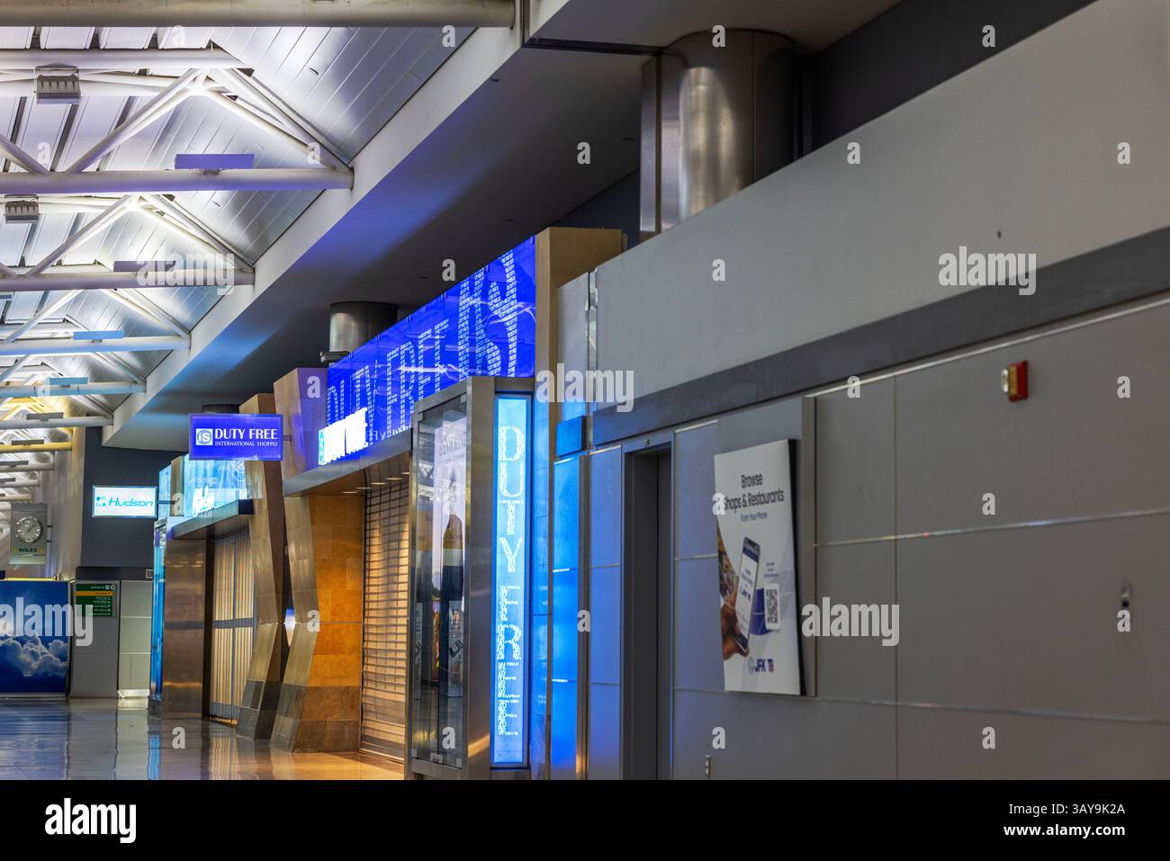 Closed duty free shops inside JFK airport terminal with illuminated ...
