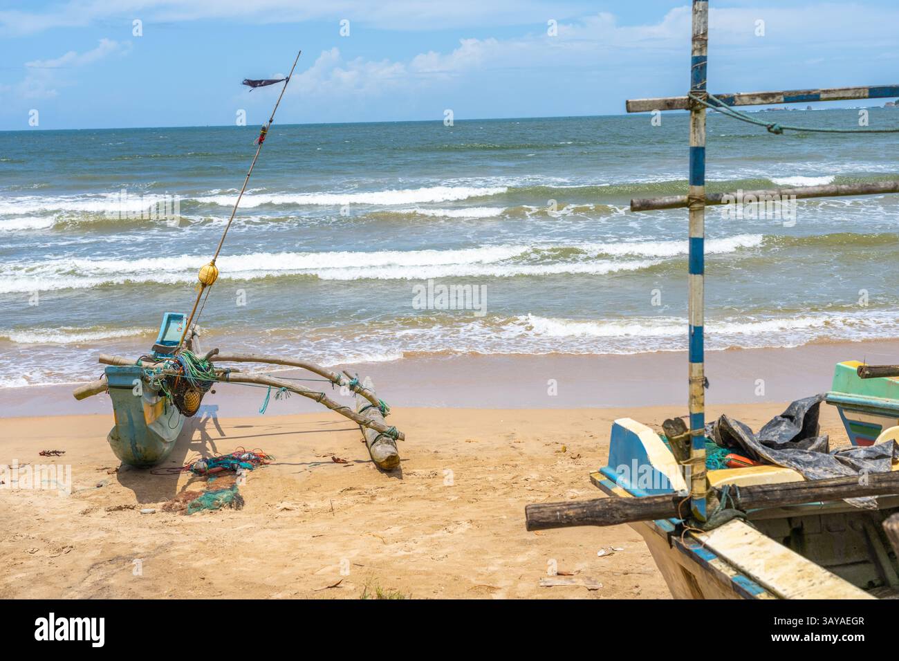 Colourful traditional style outrigger canoe with fishing nets and gear ...