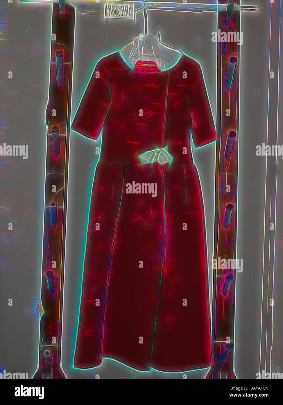 A vintage dress with a fitted bodice and flowing skirt hangs from a ...