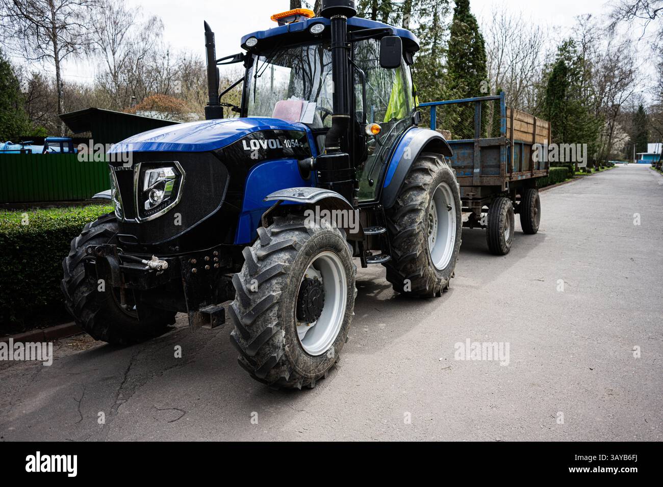 Khmelnytskyi, Ukraine - April 16, 2025: A blue Lovol tractor with an attached trailer parked ...