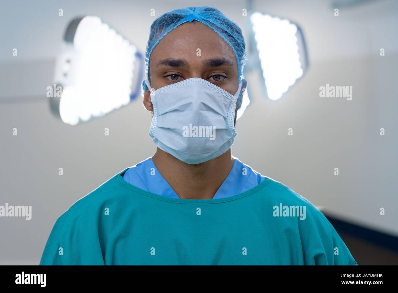 Male professional standing in operating room under LED lights, wearing ...