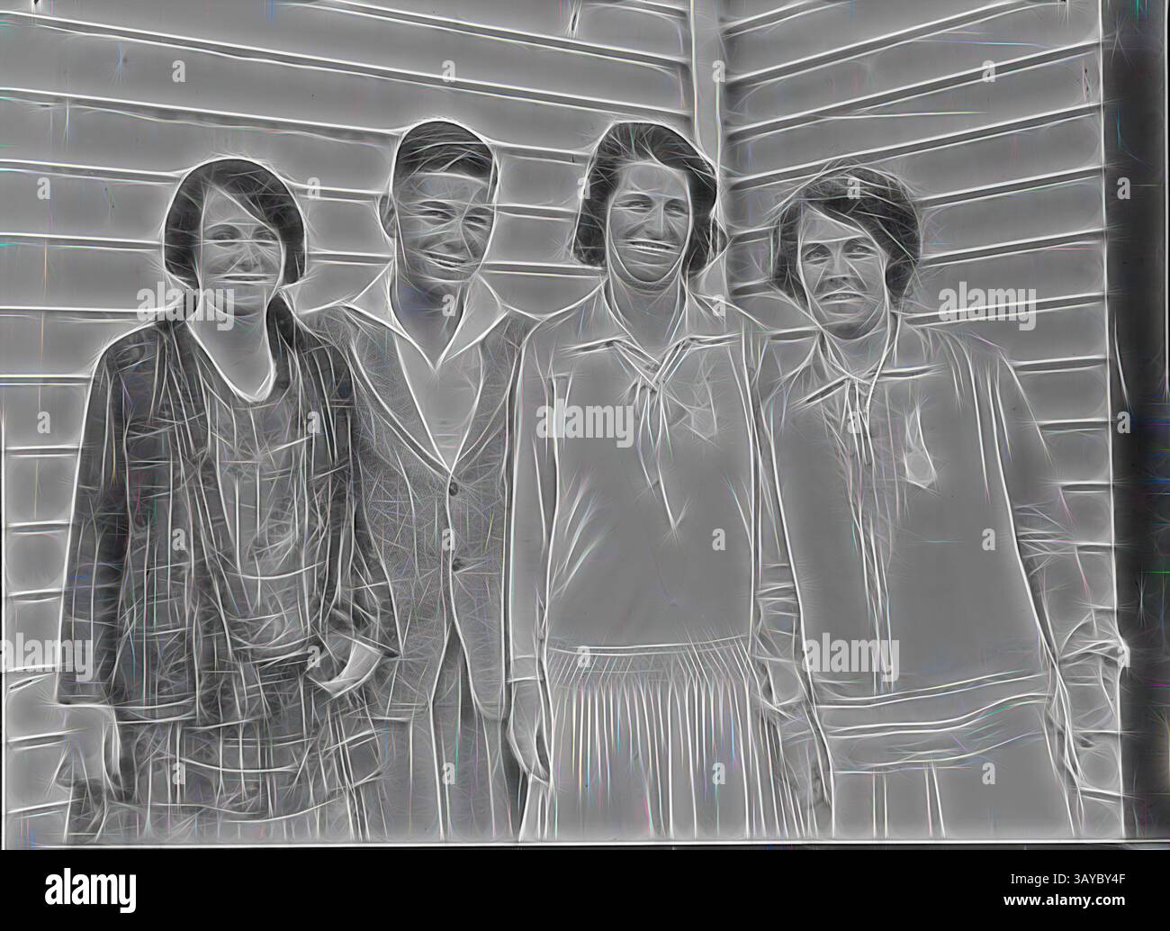 A group of four individuals stands closely together, smiling ...