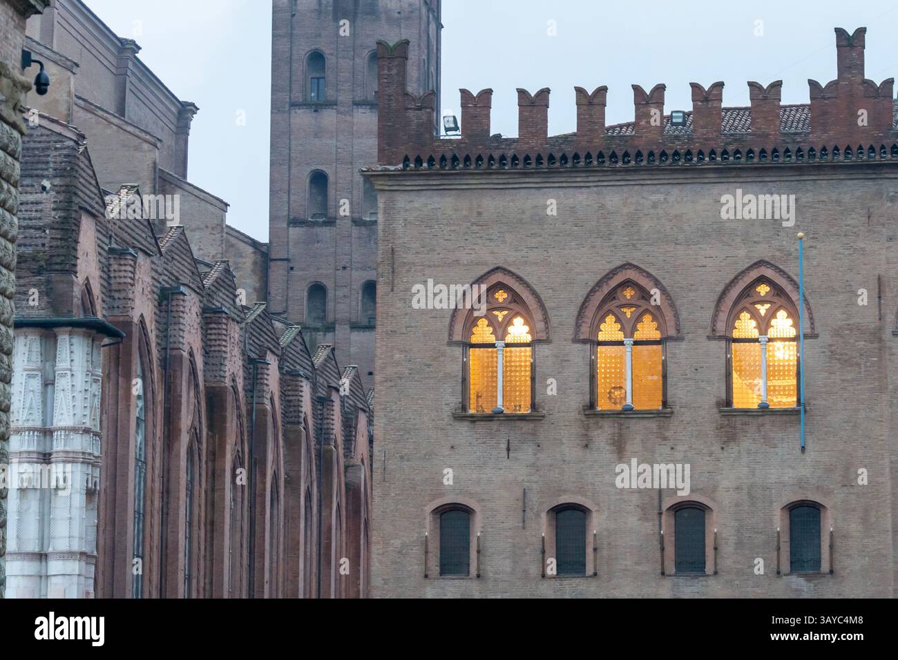 Medieval brick buildings with illuminated gothic windows in Bologna ...