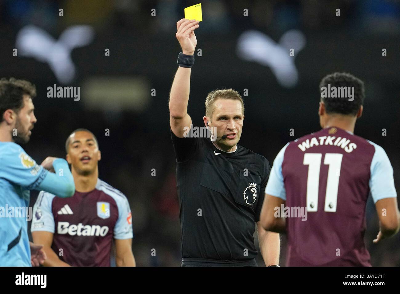 Referee Craig Pawson shows a yellow card to Aston Villa's Ollie Watkins during the English ...