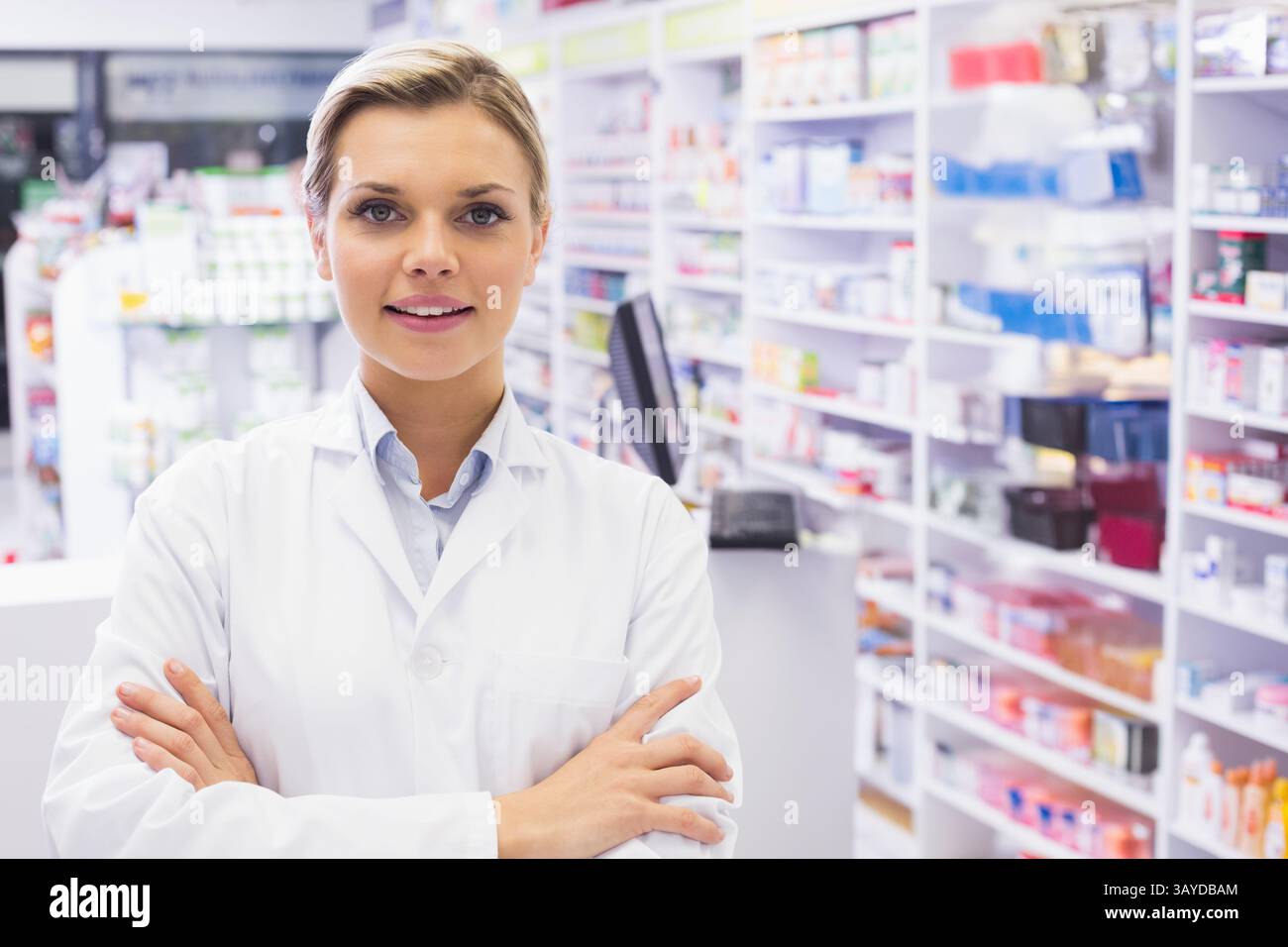 Female pharmacist standing in pharmacy behind counter with lab coat and ...