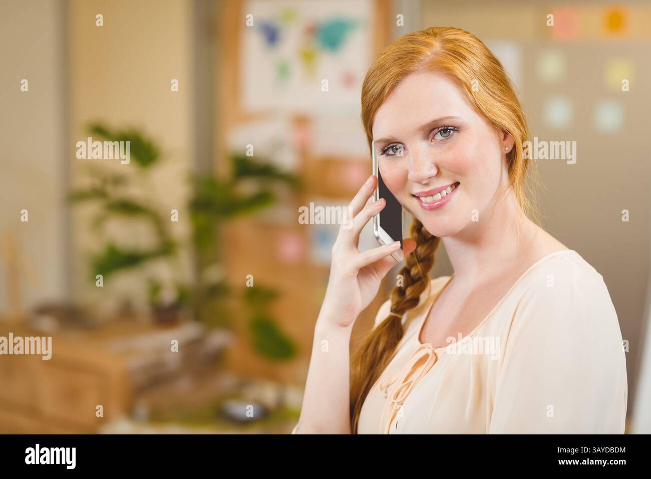 Woman holding smartphone to ear and smiling in home office, with ...
