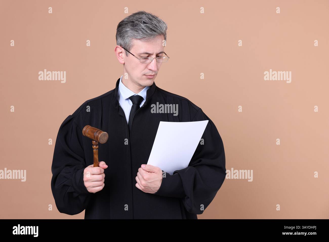Judge with mallet and document on beige background Stock Photo - Alamy
