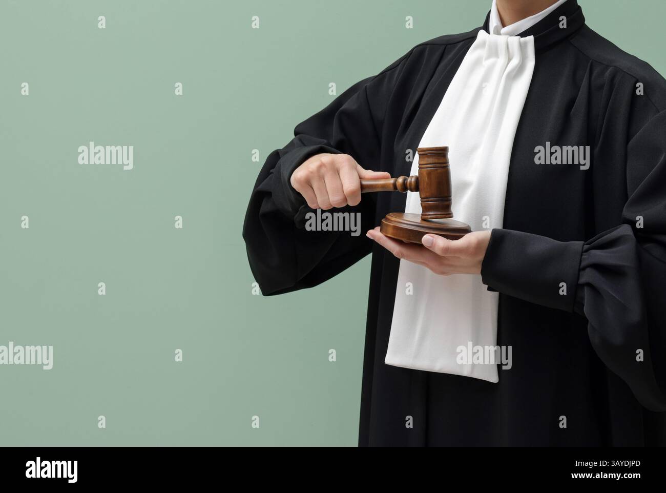 Judge with mallet and sound block on light green background, closeup ...