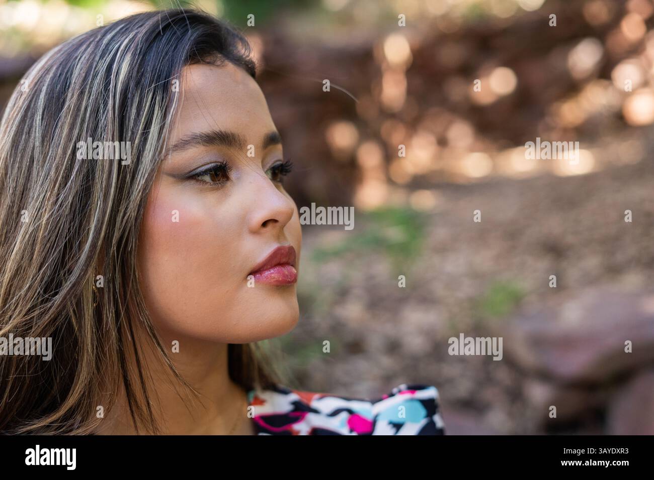 A young woman poses elegantly and gracefully in a beautiful natural ...