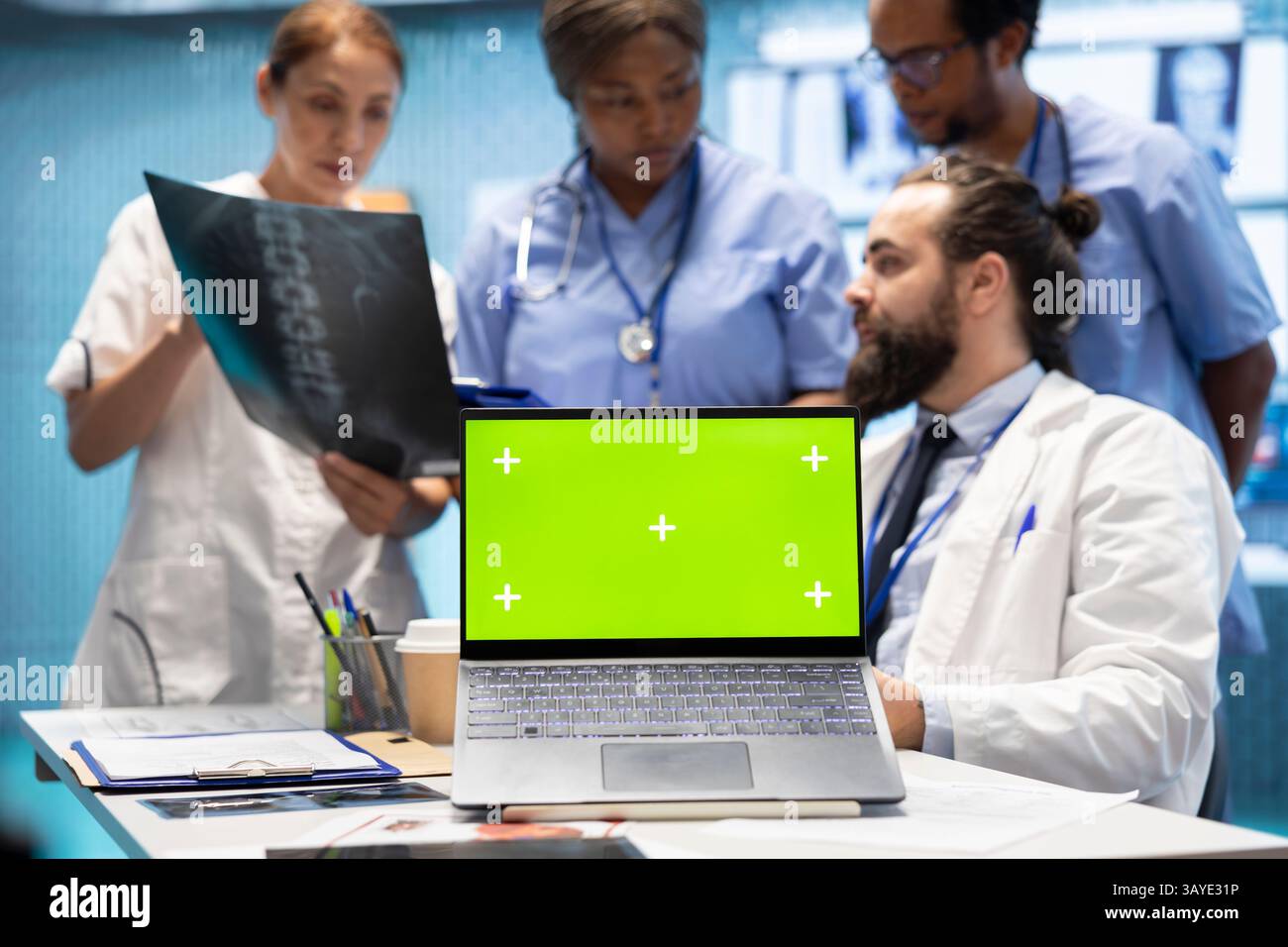 Team of doctors consulting analytics next to green screen on laptop in ...