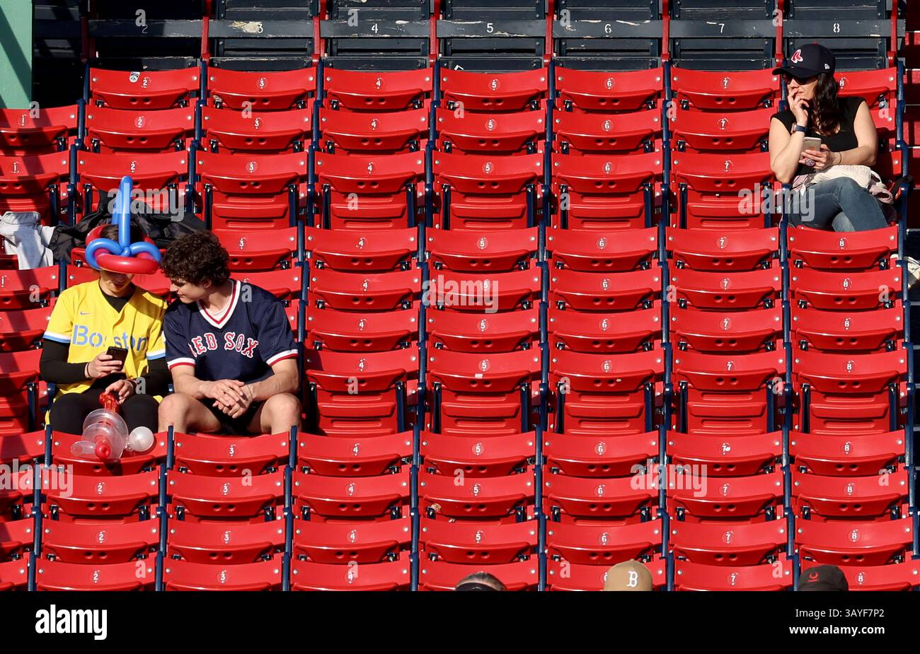 Boston Red Sox fans wait in the outfield seats before a baseball game ...